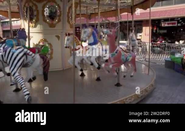 An empty carousel with horses spinning around its axis. Old carousel ...