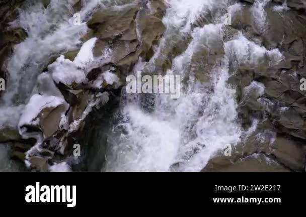Rapid Flow of Water from a Mountain Creek and Stone Rapids with Snow in ...