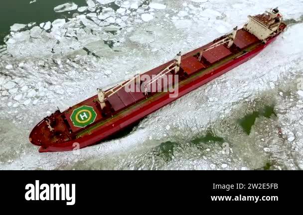 Aerial above epic huge steel ship breaks ice by bow of ship and floats ...