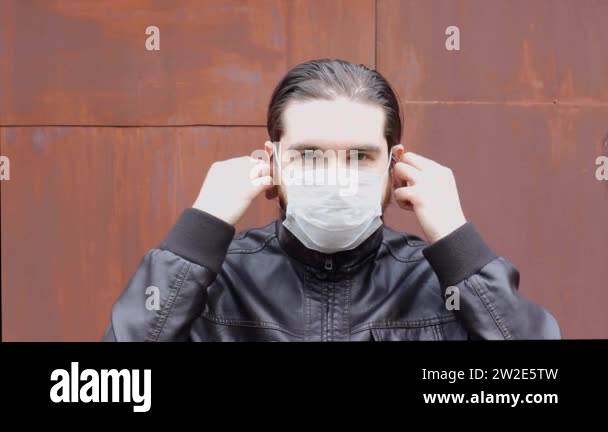 an adult man in a disposable mask sneezes. Instructions on how to wear ...