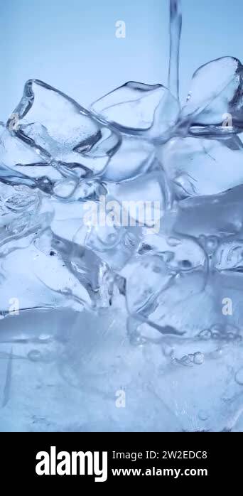 Pouring soda water with ice and bubbles in the glass. close-up slow motion. Refreshing, fresh ...