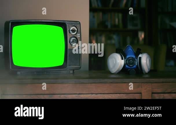 Hand picking up a Face Respirator Mask and a Retro TV with Green Screen ...