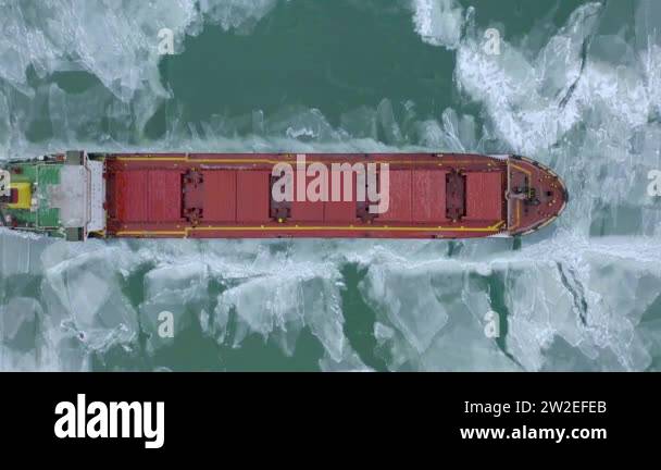 Aerial above epic huge steel ship breaks ice by bow of ship and floats ...
