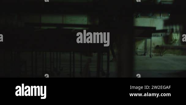 Zombie woman walking through passage near the building at night. Woman ...