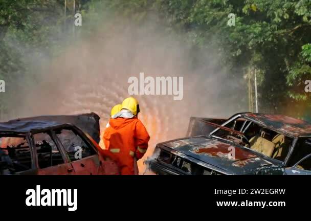 Firefighter fighting with fire flame protection property. Fireman wear ...