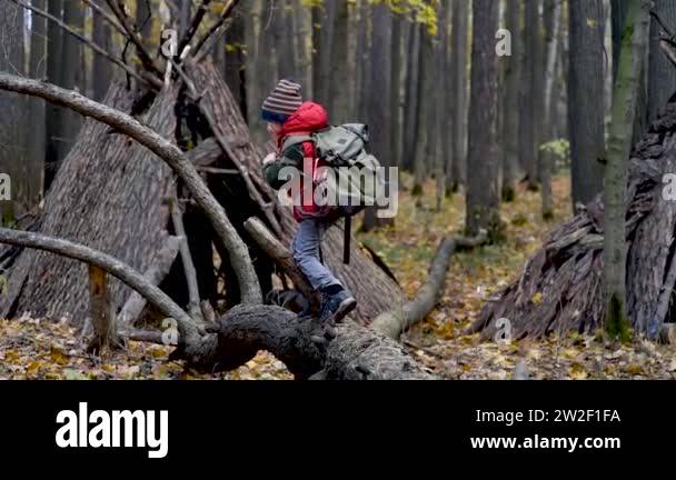 Little boy scout with backpack and rope during hiking in autumn forest ...