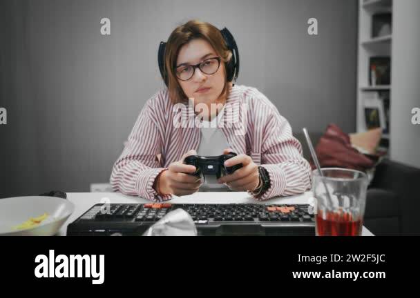 Boring Young Gamer Girl with headphones playing in Video Games on a ...