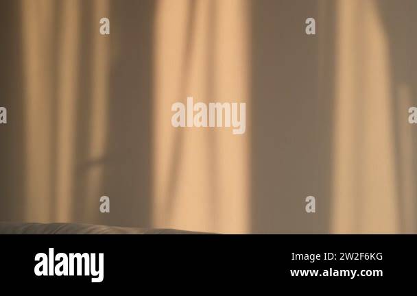 The incident light from the window moves along the wall, the shadow of ...