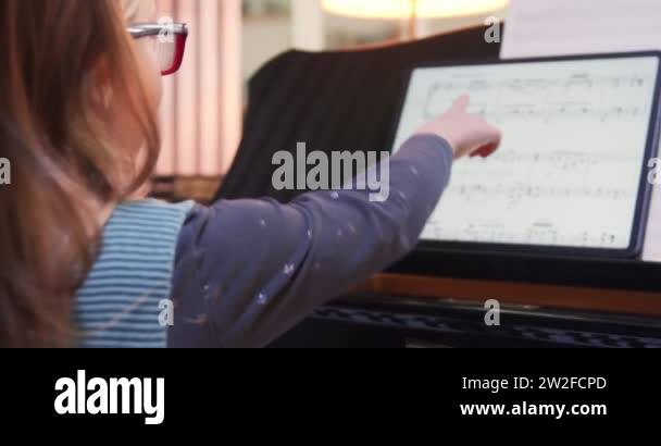 Kid learning to play piano from teacher. Little girl learning sheet ...