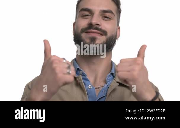 proud young man in denim shirt pointing fingers, making thumbs up ...
