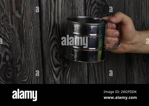 A man puts flour in a hand sieve for sifting. Starts the screening ...
