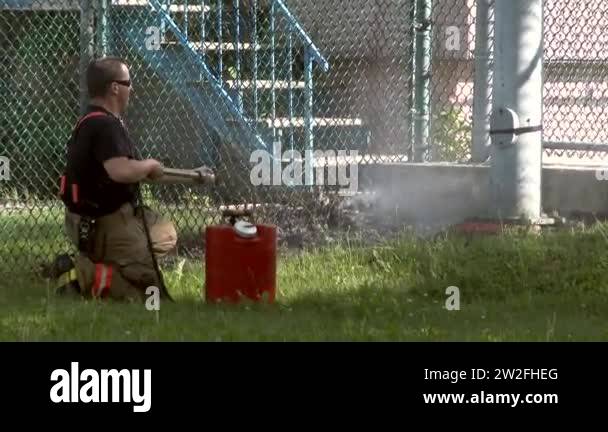Fireman using backpack fire pump to extinguish grass fire Stock Video ...