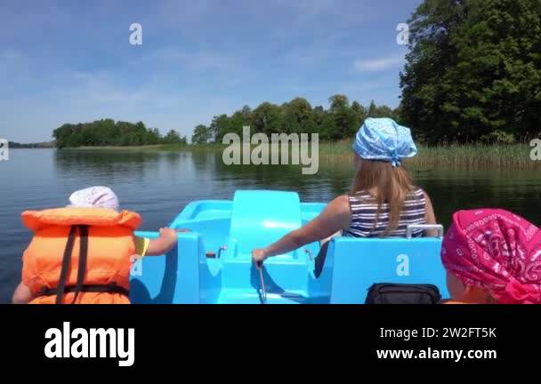 Woman with two children boy and girl ride catamaran boat on lake ...