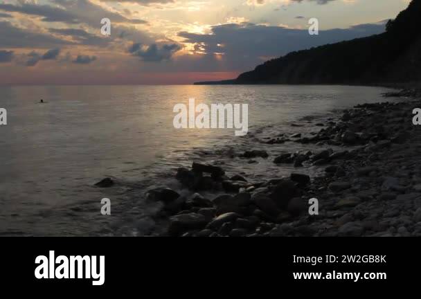 Red sunsets over sea . The sun touches horizon. Red sky, yellow sun and ...