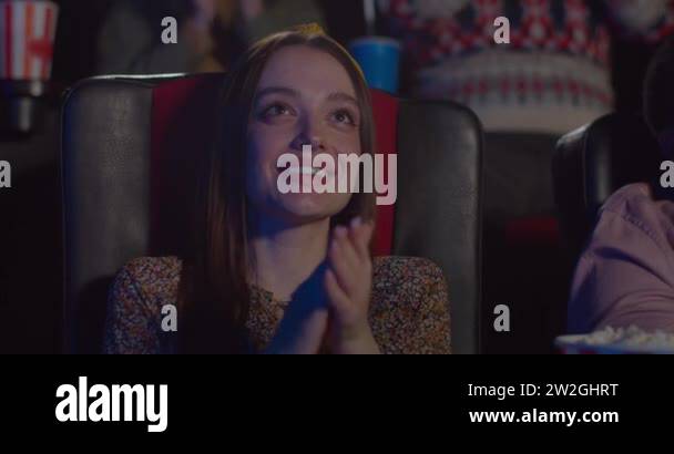 Close up of young woman applauding and smiling after watching good ...