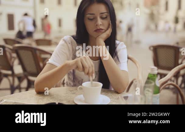Young worried beauty woman is sitting with coffee at patio in HD VIDEO ...