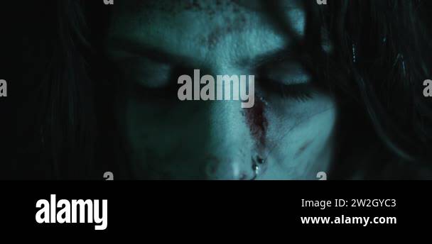 Terrifying creepy zombie woman with bloody face opening her white eyes ...