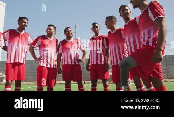 Side view of a multi-ethnic group of male football players wearing a ...