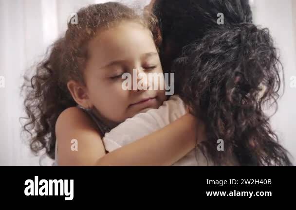 Happy little kid hugging foster care parent mother with eyes closed ...