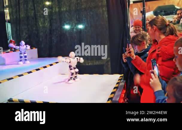 People watch dancing robots at a technology trade show. Robotic dance ...