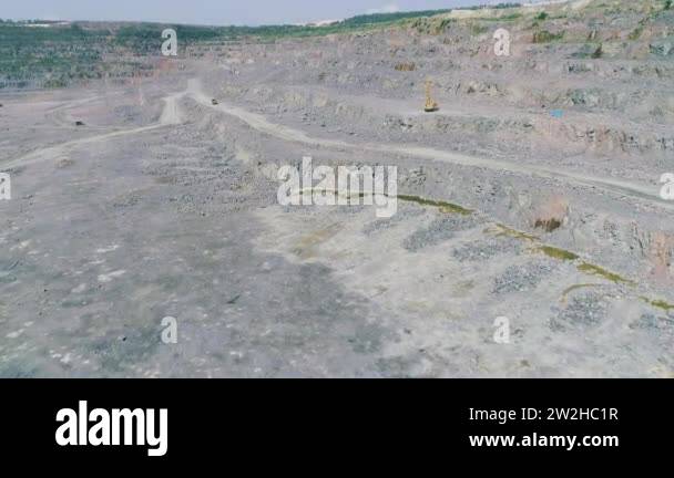 Mining dump trucks in large granite open pit mine. Loaded truck rides ...