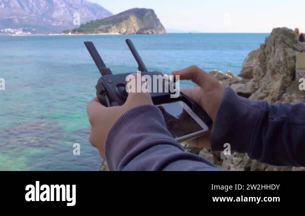Man holds drone control panel in hands and moves sticks to left and ...