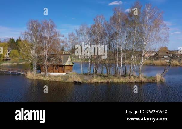 Morning landscape, wooden hunting lodge, on a small man-made island. A ...