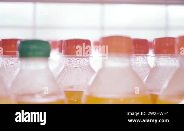 Lots of plastic drinks bottles in the shop by the window. CLOSE-UP. Row of carbonated soft drink ...