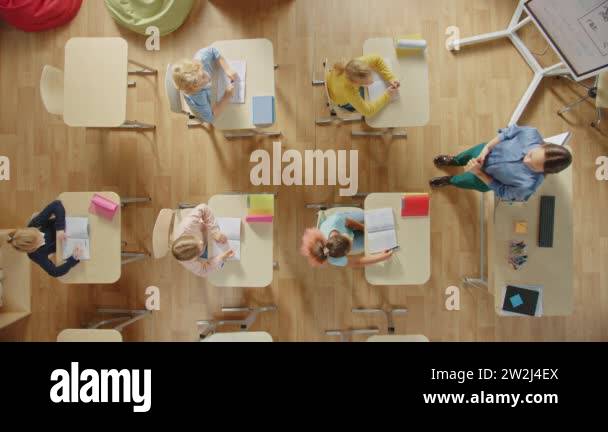 Bright Elementary School Classroom: Children Sitting at their School ...