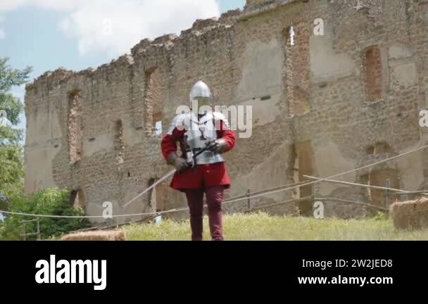 Medieval knight dressed in traditional heavy armor and holding metal ...