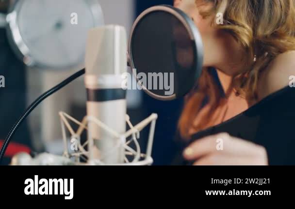 Beautiful face of a singer with bare shoulders singing into a ...