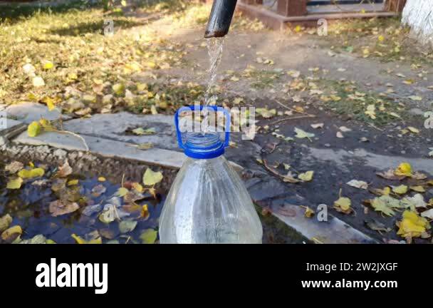 plastic bottle is slowly filling with water outside. poor water ...