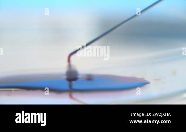 Drops of blood falling on a smooth surface forming a pool in a modern ...