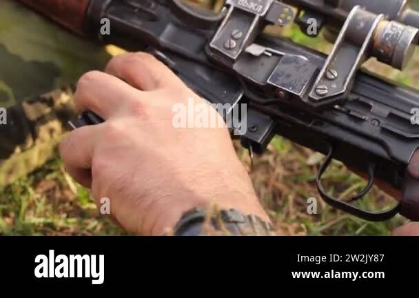 Close-up of a male hand inserting a magazine with ammunition into a ...