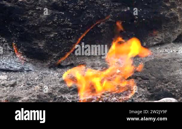 Flame of Methane Underground Emerges From Crack Between Rocks and Burns ...
