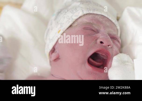 Close up portrait of a crying newborn in a primordial grease which. The ...