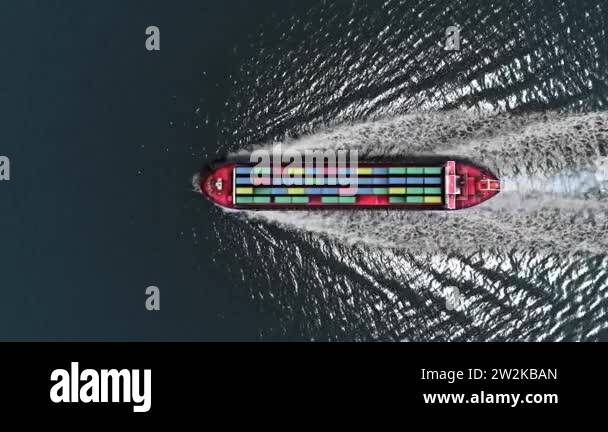 Airplane flies over Cargo ship with containers in the sea- aerial ...