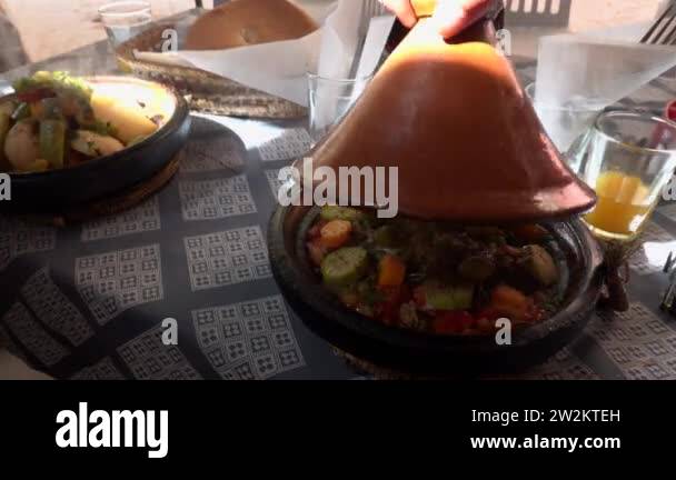 Traditional moroccan Tajine food cooking in pots on table in cafe with ...