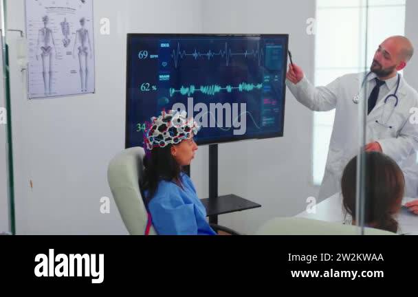 Nurse wearing headset with sensors during neuoroscience experiment ...