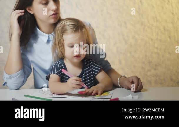Young female babysitter mom teaching happy cute kid daughter drawing ...