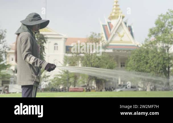 Real peoples life in Cambodia: A woman hoses grass. Phnom Penh. Asia ...