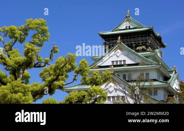 4K, Main tower of Osaka Japanese Castle behind rock wall, famous ...