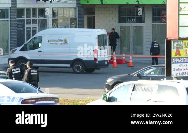 Police officers guarding scene of murder with dead body on the ground ...