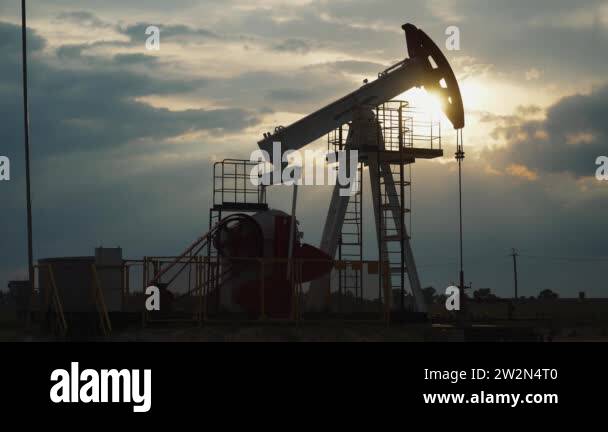 Resource extraction, an oil rig in the field pumps out oil, view of an ...