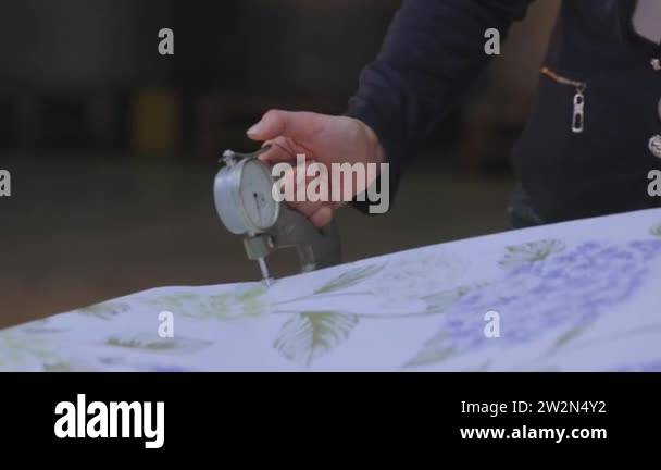 Quality control of wallpaper in a factory, checking the thickness of ...