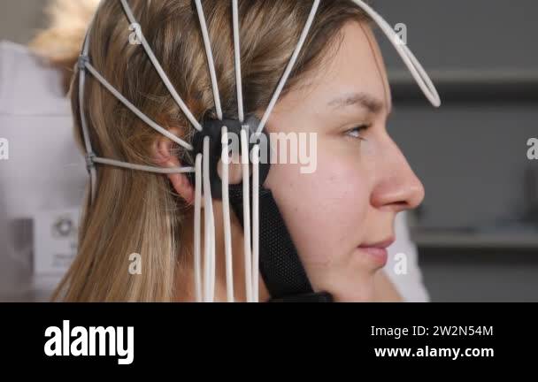 Doctor connecting electronic sensors with wires to female patient ...
