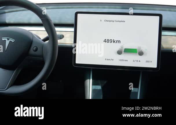 CLOSE UP: Touchpad inside a Tesla car displays the battery charging is ...