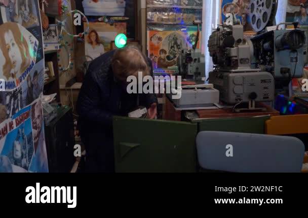 An old woman searcing for cine film to play in film technique museum ...