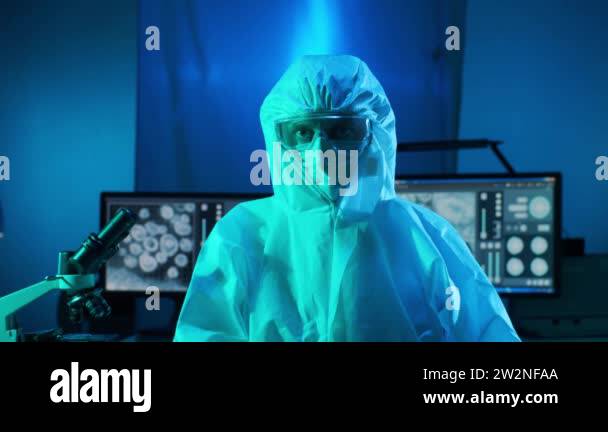 Scientist in protection suits and masks working in research lab using ...