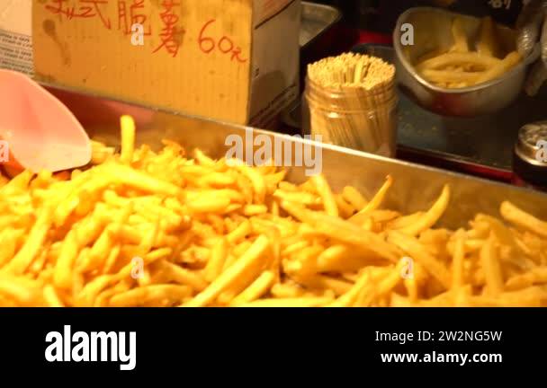 4K of a street asian vendor sell french-fried. A popular food at street ...